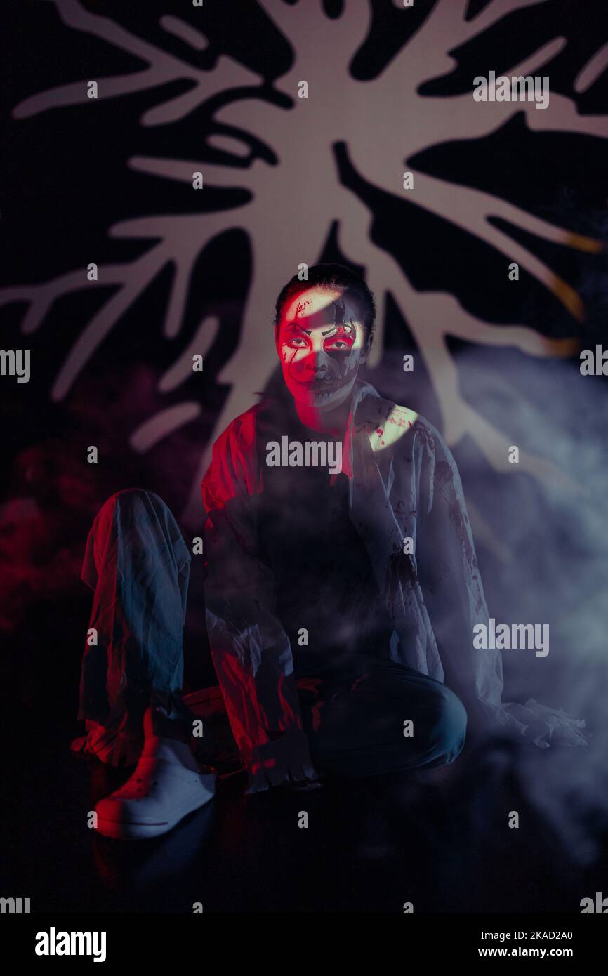 Young woman portrays bloodthirsty zombie with horror wounds on her face ...