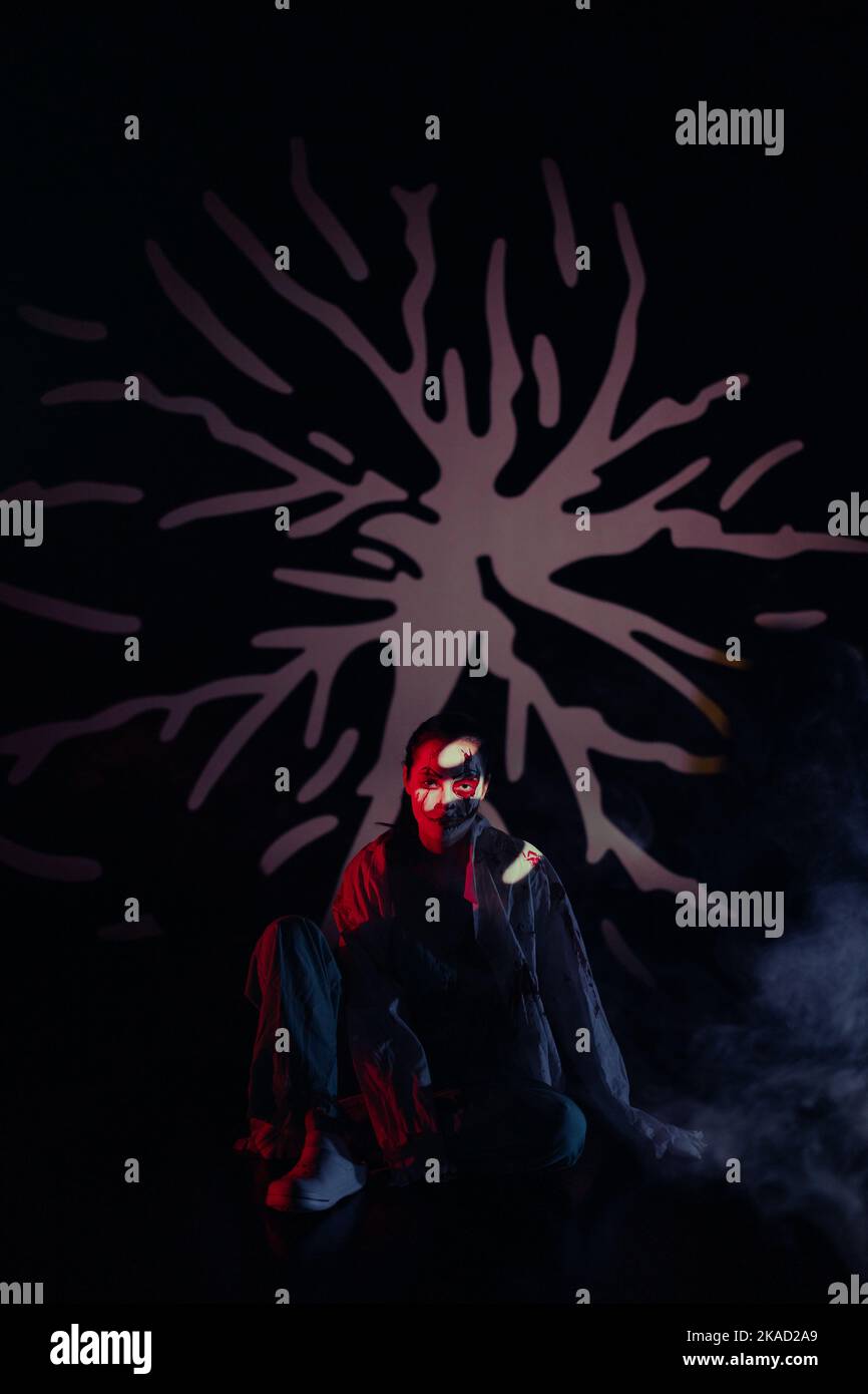 Young woman portrays bloodthirsty zombie with horror wounds on her face ...