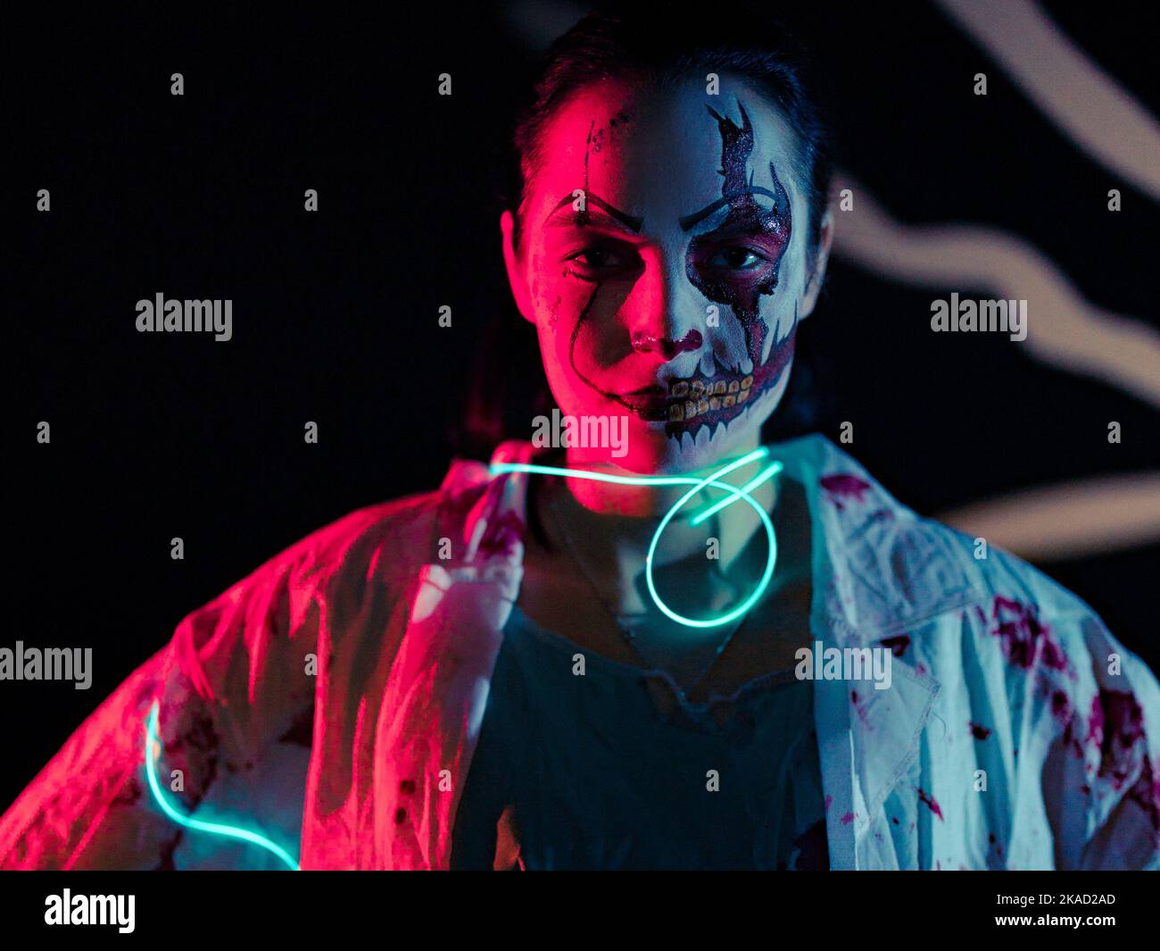 Young woman with glowing blue led band portrays bloodthirsty zombie ...