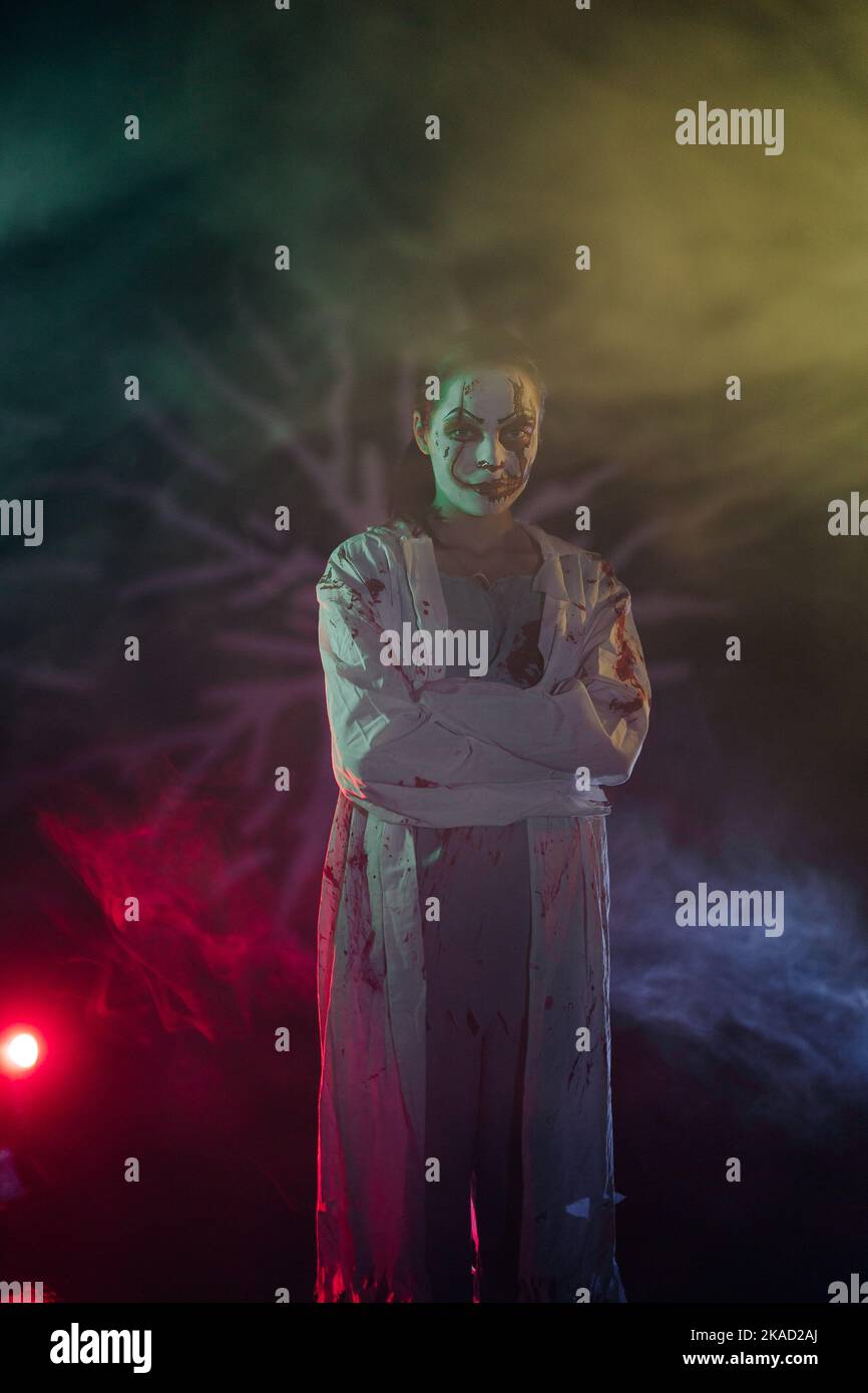 Young woman portrays bloodthirsty zombie with horror wounds on her face ...