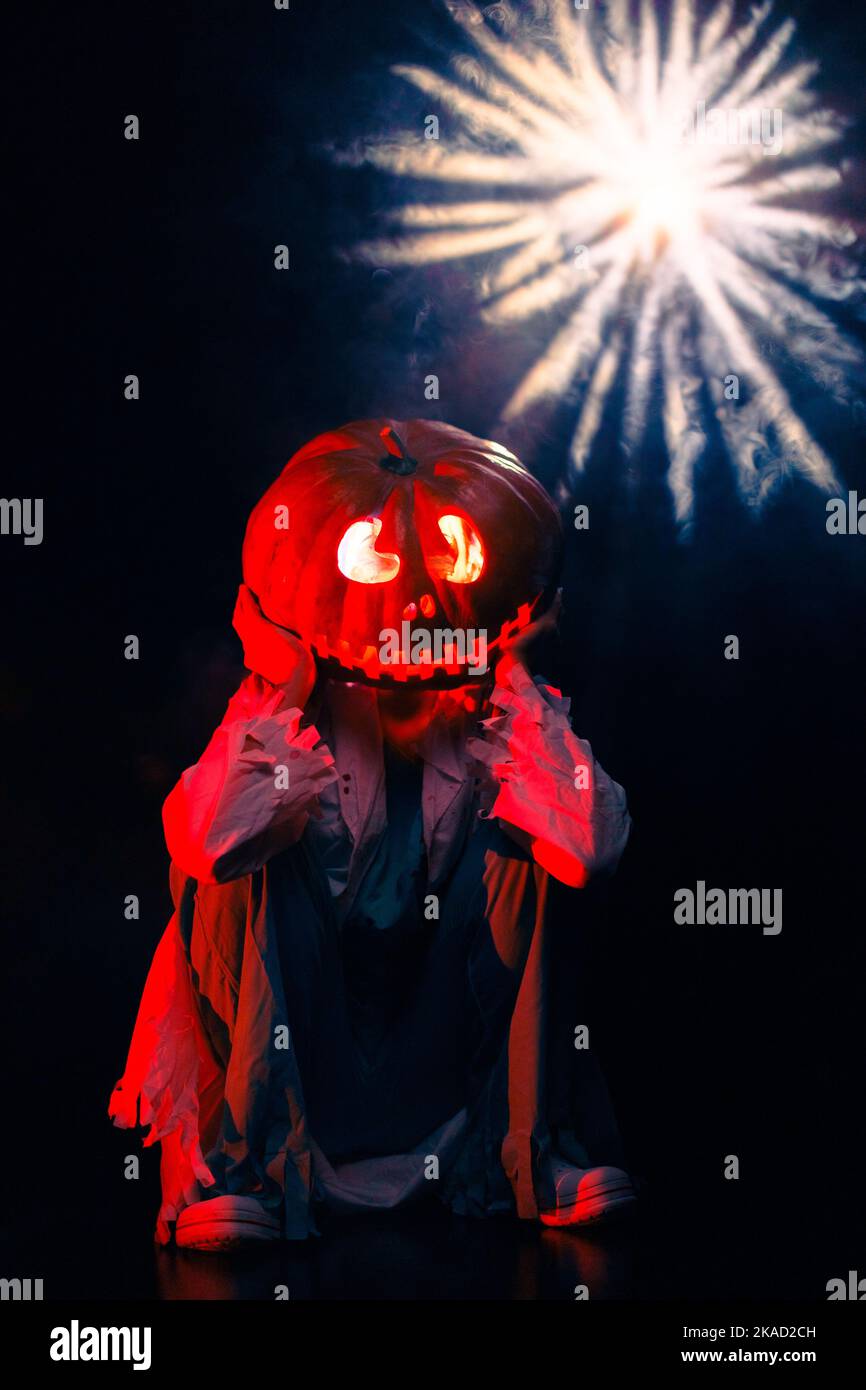 Young woman holds jack o lantern from pumpkin with glowing eyes on her ...
