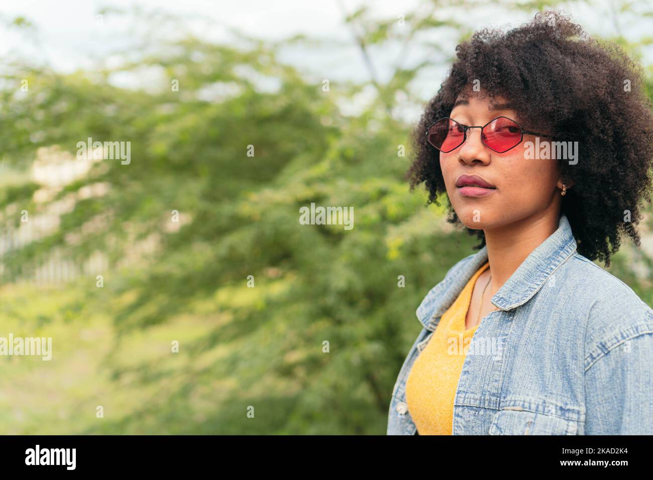 Serious woman looking back to camera while standing outside over a ...