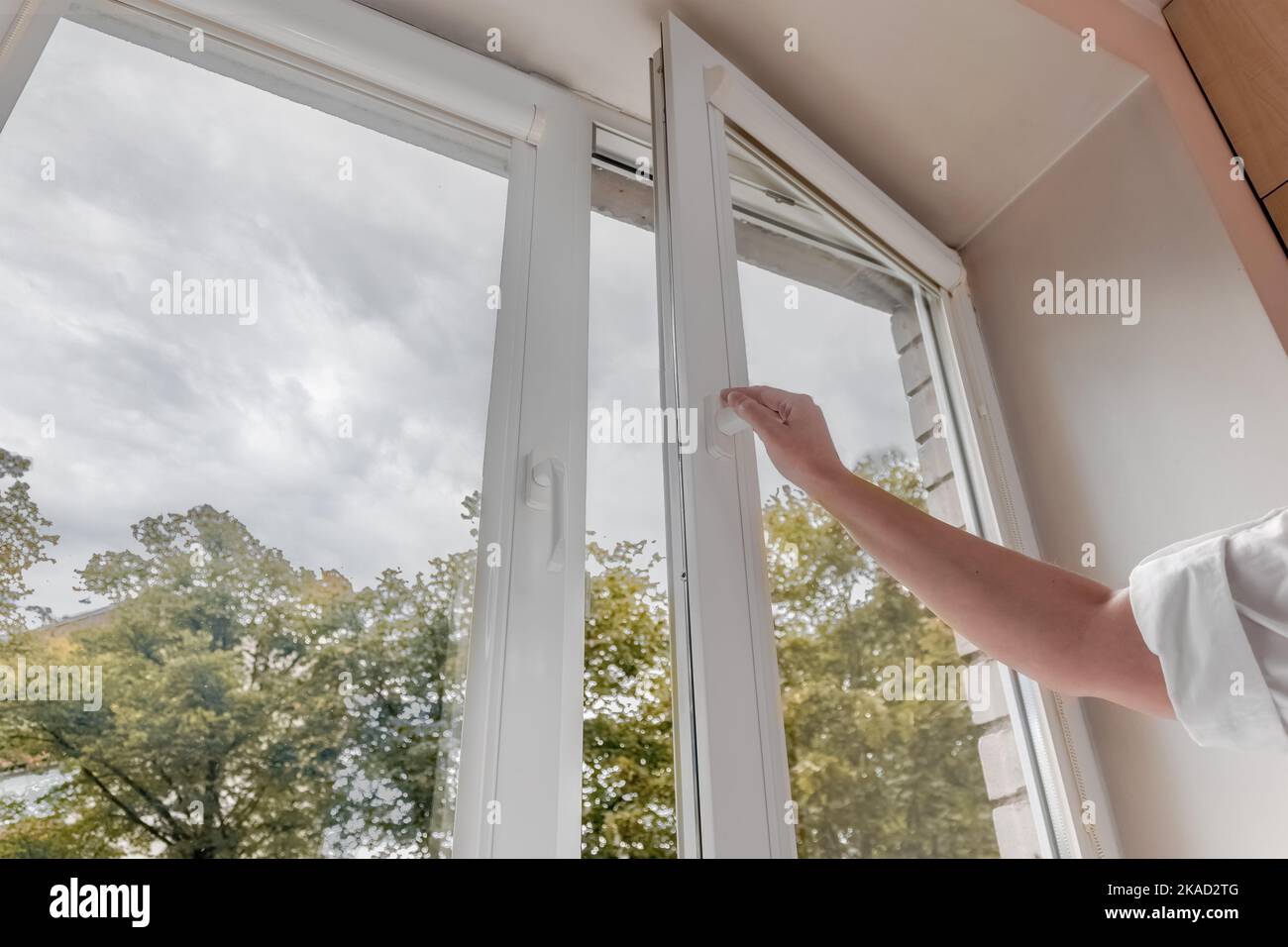 woman hand open pvc window with double glazing. Room ventilation ...