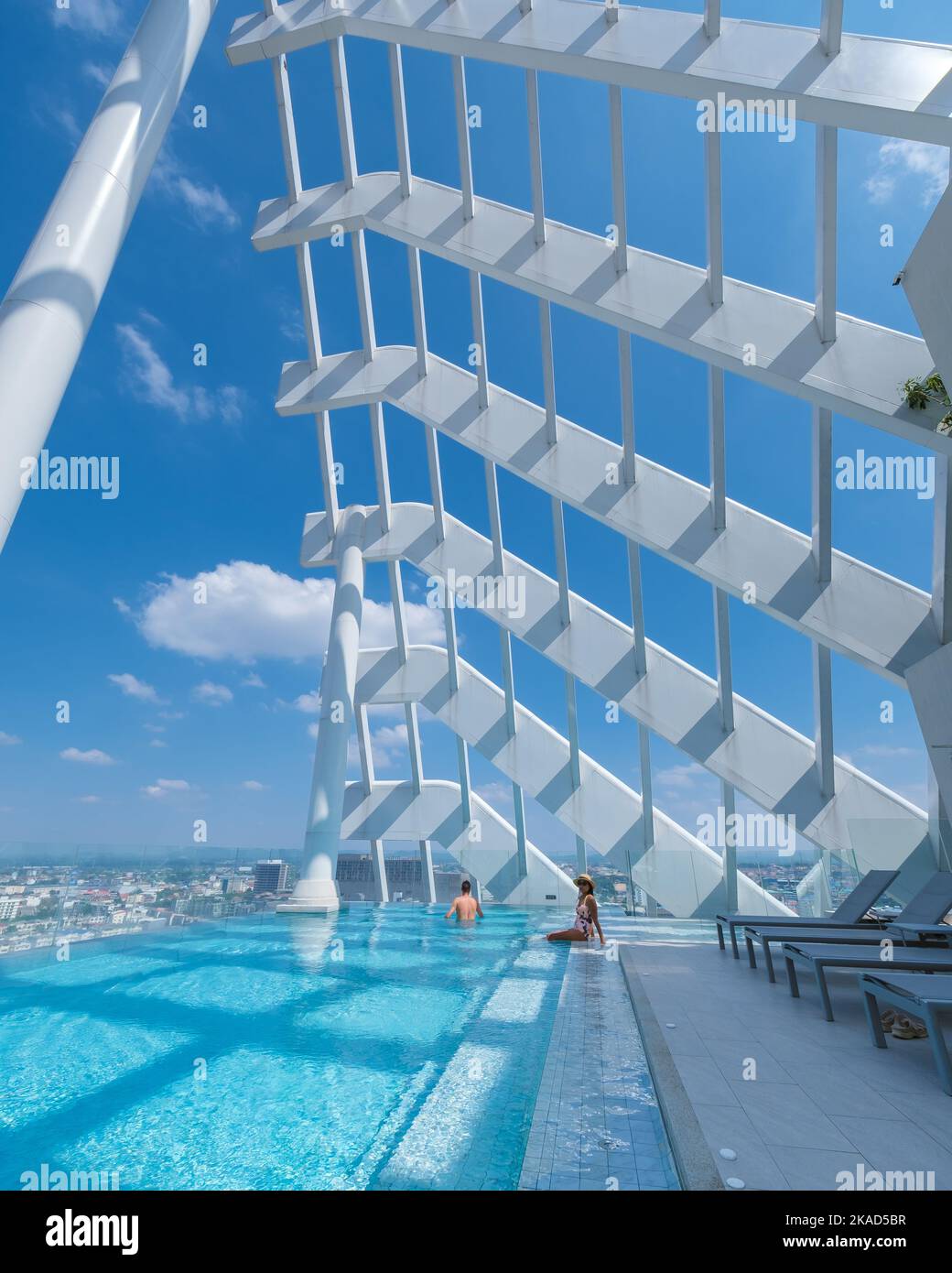 couple men and women relaxing at a rooftop pool of a luxury hotel Stock ...