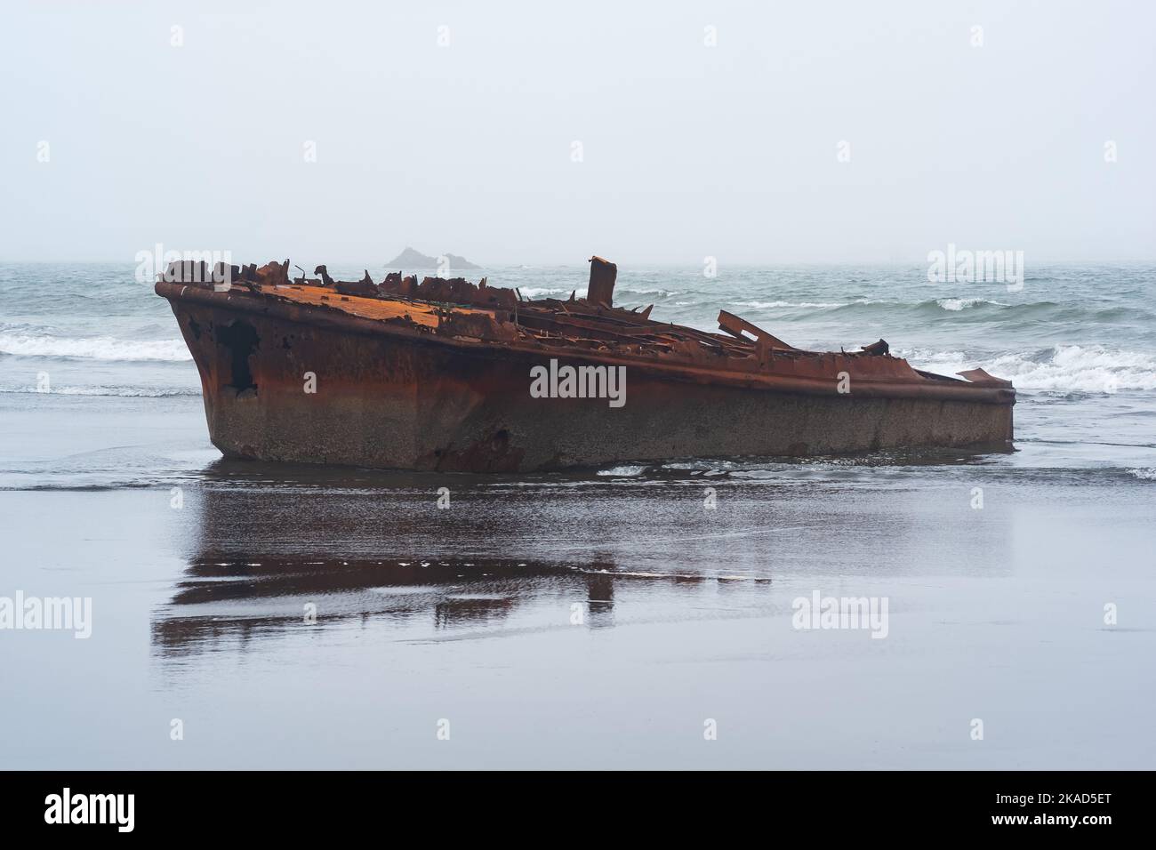 rusty shipwreck, remains of a ship washed ashore against a foggy ...