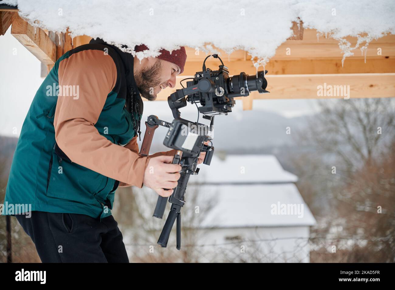 Happy videographer man shooting footage, using camera mounted on gimbal ...