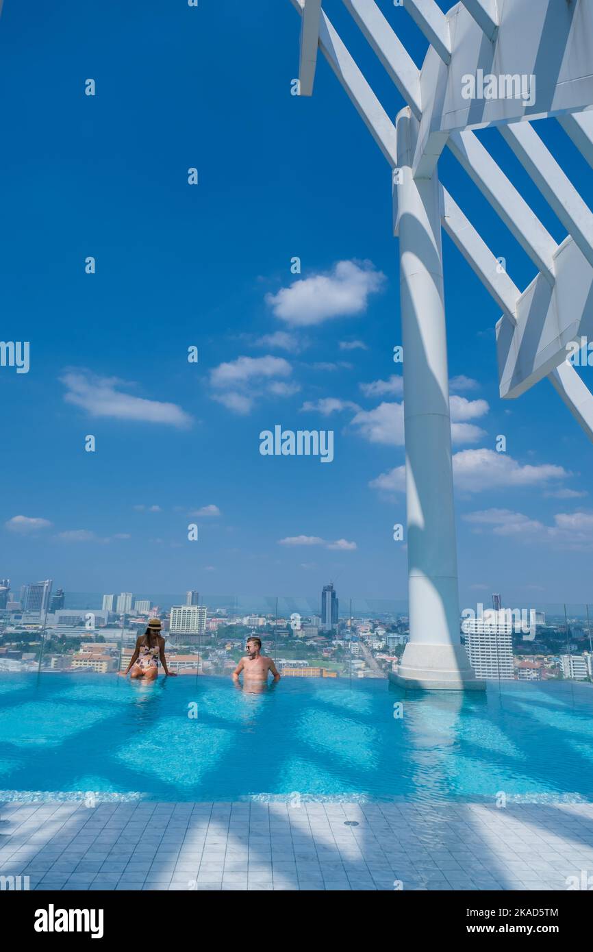 couple of men and women relaxing at a rooftop pool of a luxury hotel ...