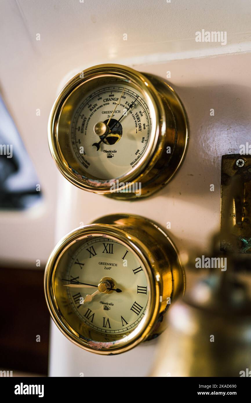 Old golden clock and nautical instruments inside a catamaran ship Stock ...