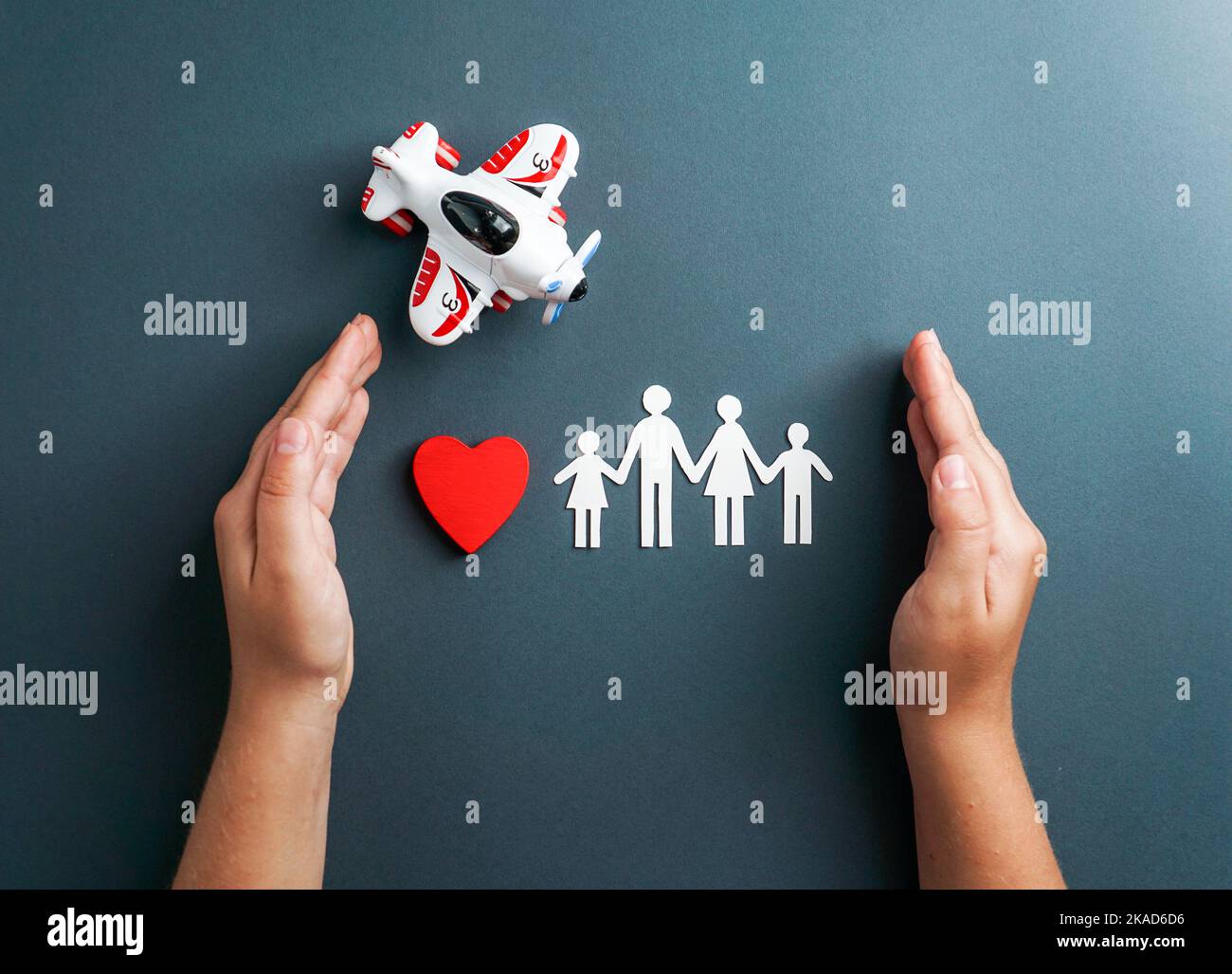 hands holding airplane and paper family cutout, life health insurance ...