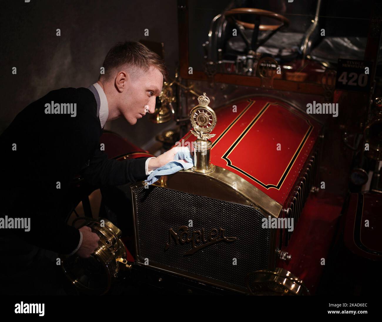 Auction staff Alex Grey polishes the hood ornament of a 1904 Napier ...