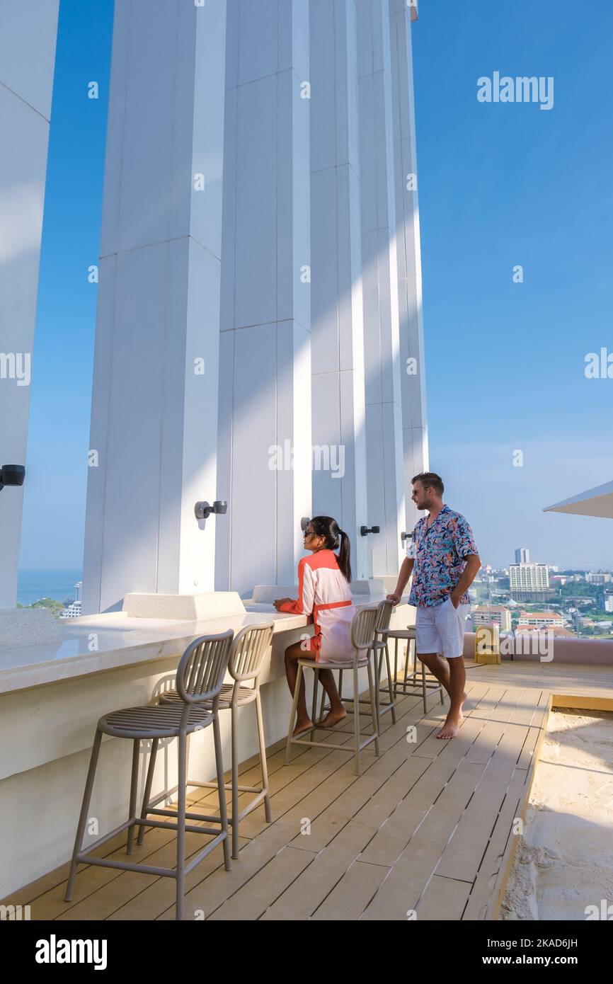 couple of men and women visit a rooftop restaurant looking out over the ...