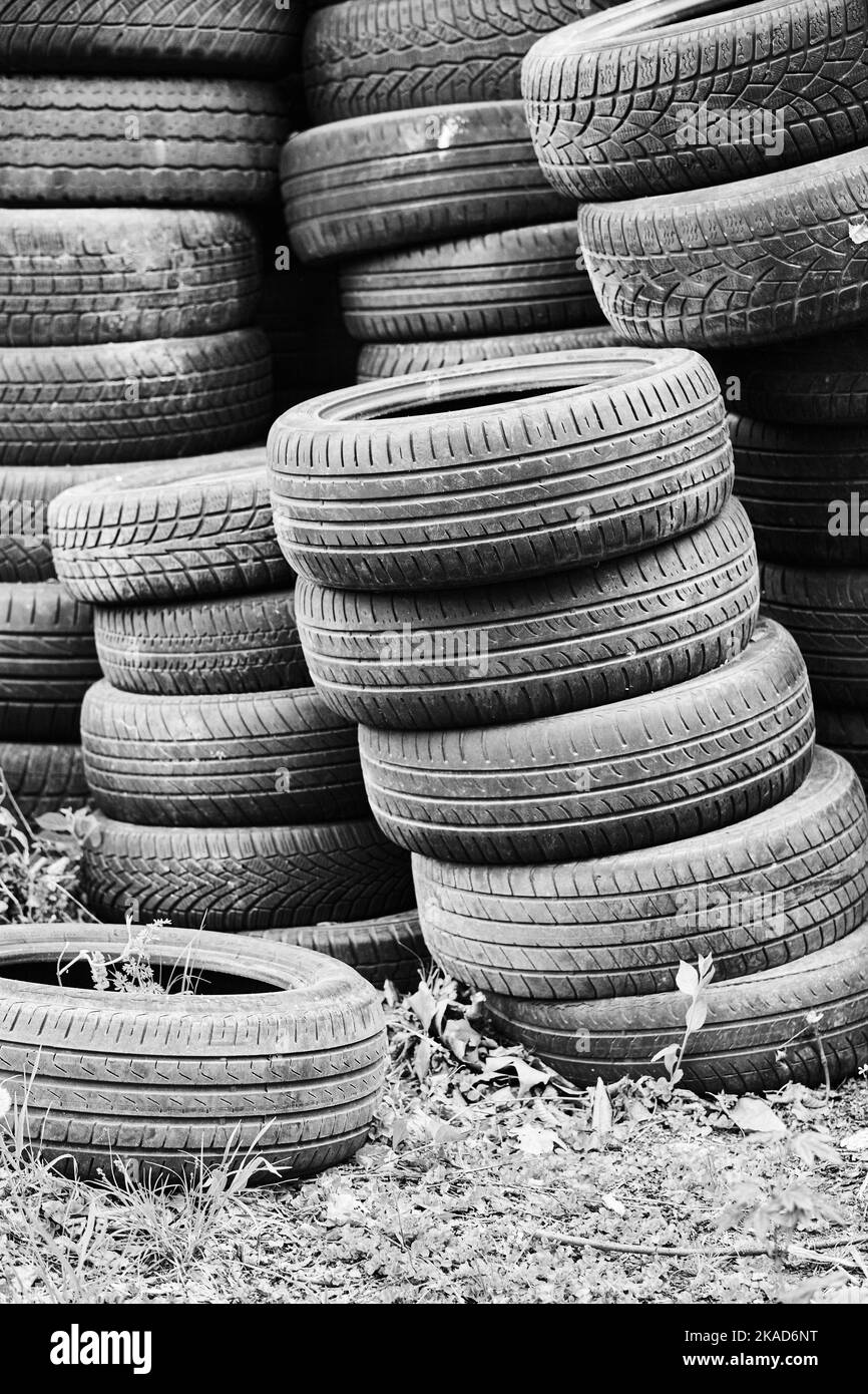 A vertical grayscale shot of many used old car tires Stock Photo - Alamy