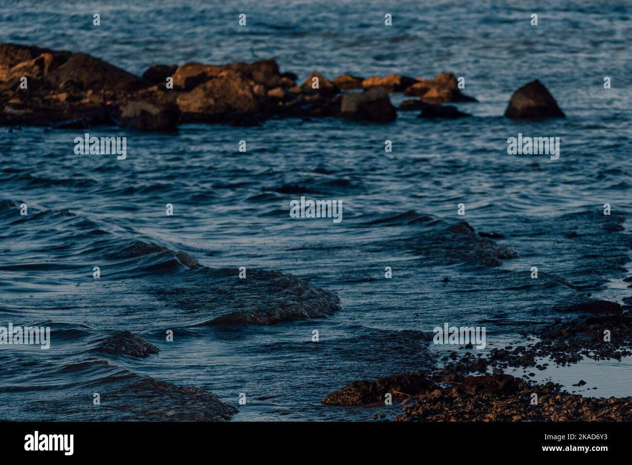 The waves crashing into the rocks making foam Stock Photo - Alamy
