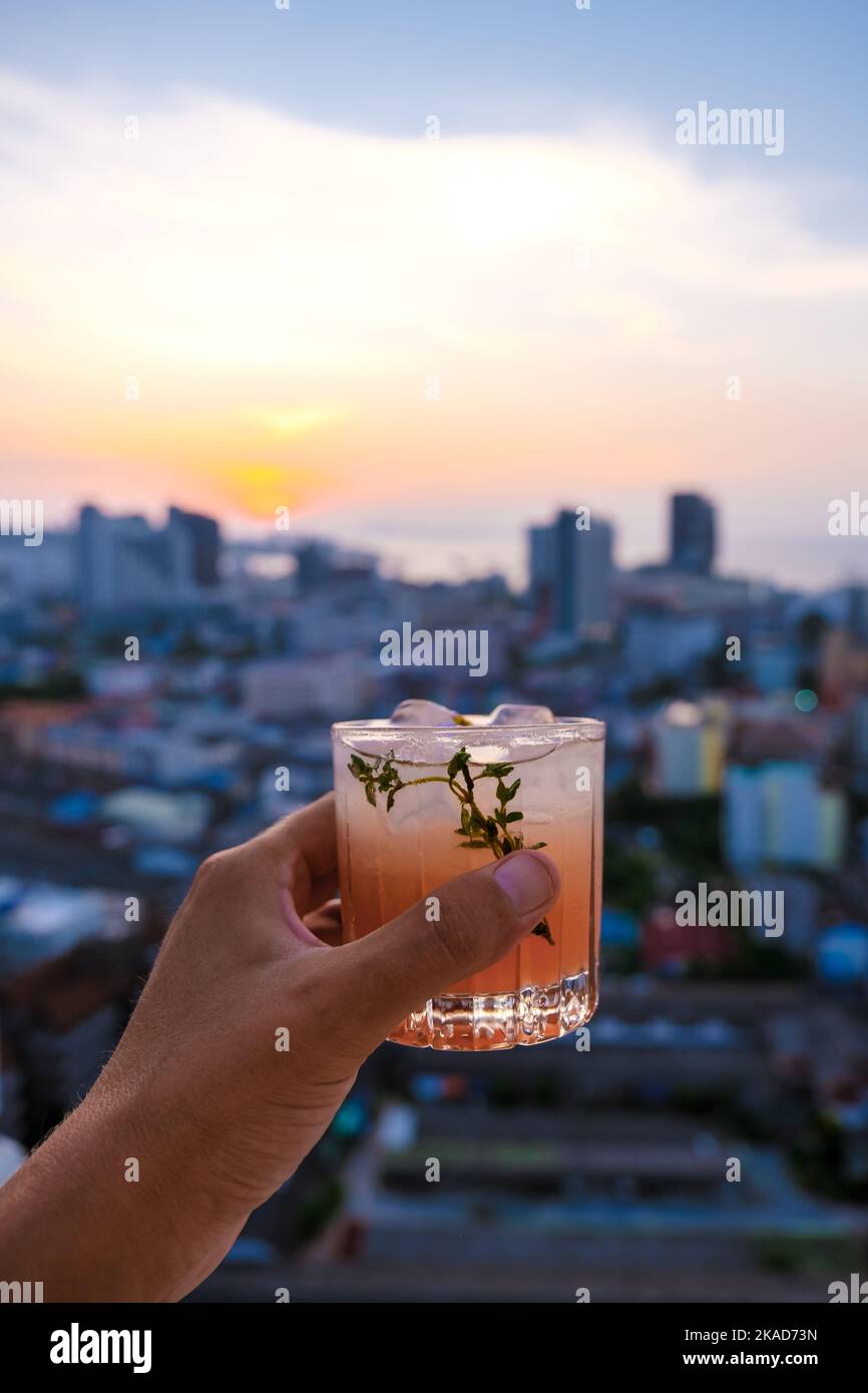 cocktail drinks on a rooftop bar in Pattaya Thailand during sunset ...