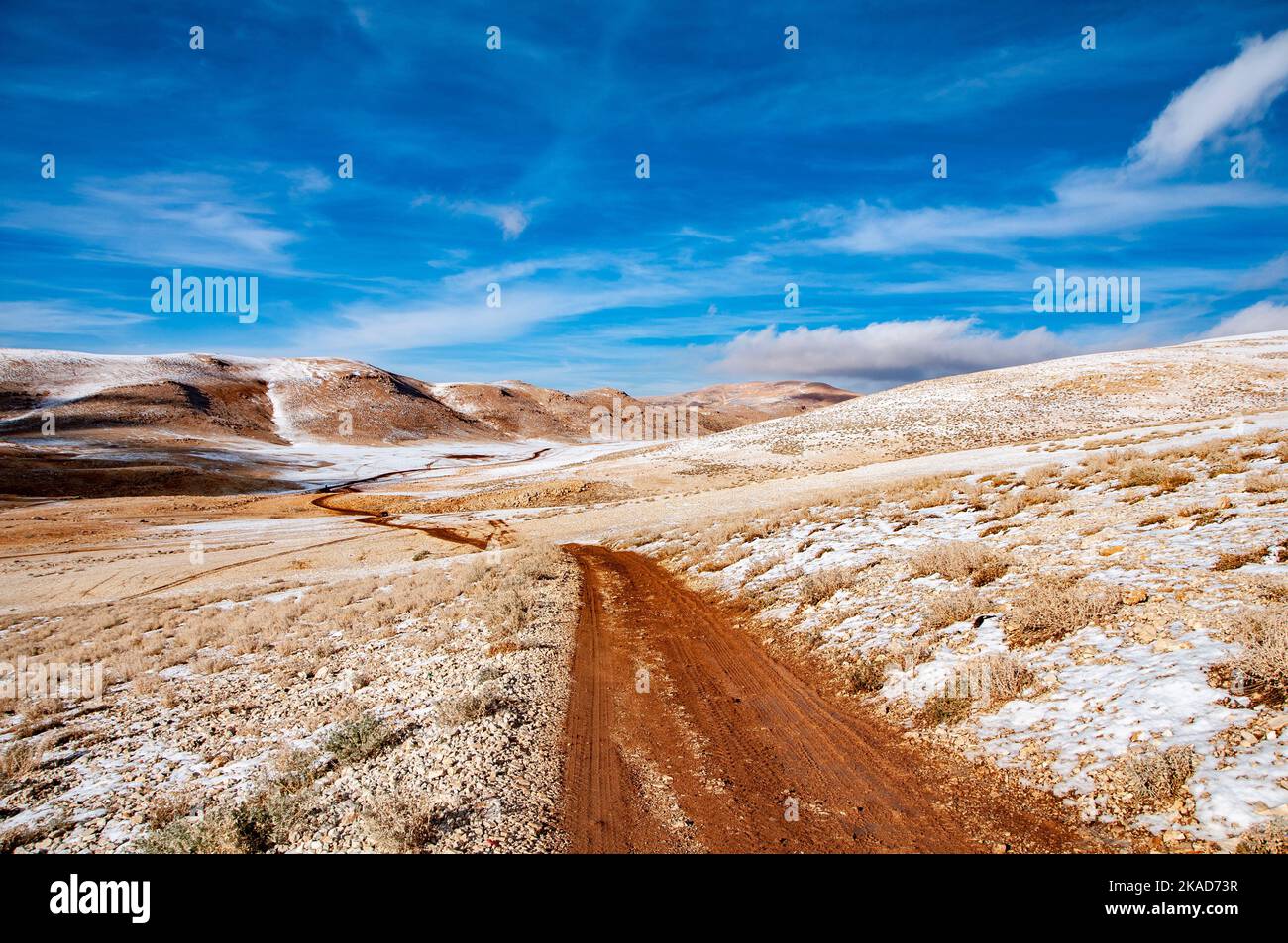The Desert road covered with light snow, the black peak highest ...