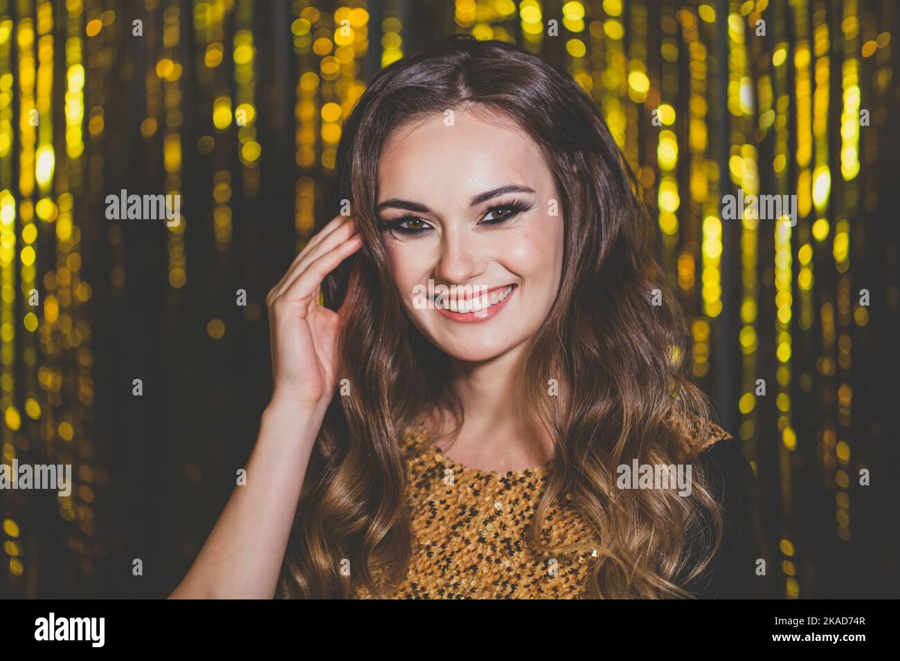 Happy cheerful woman with makeup and long wavy brown hair smiling on ...