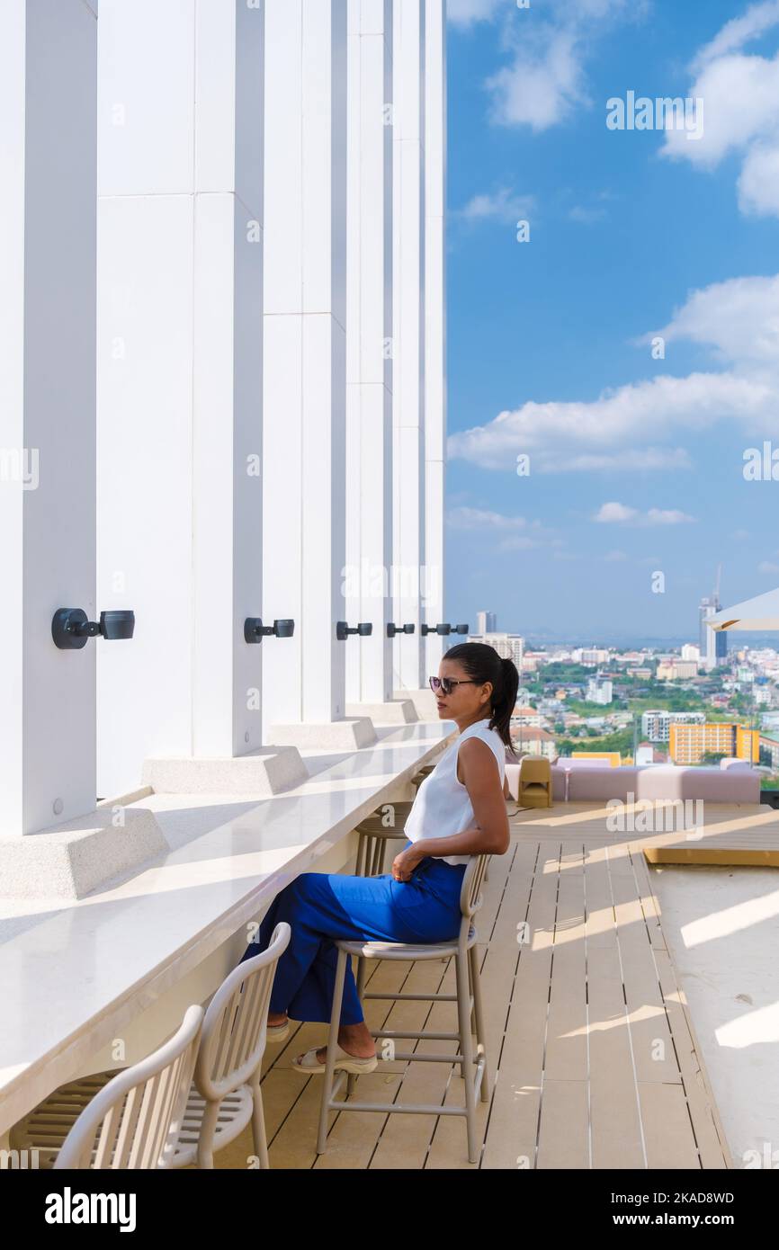 young Thai women visiting a rooftop bar looking out over the city Stock ...