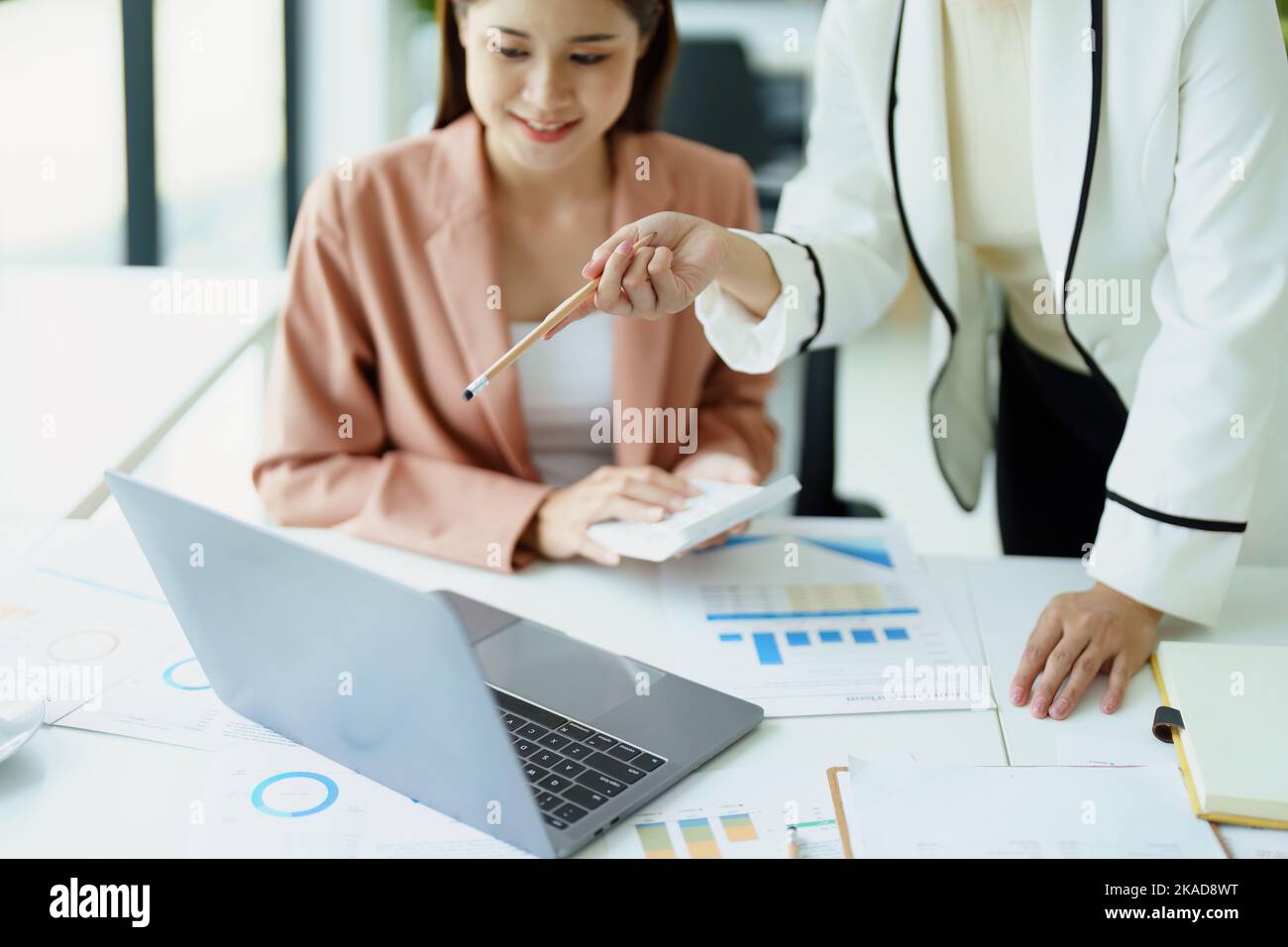 beautiful female employees discussing while working on a computer Stock ...