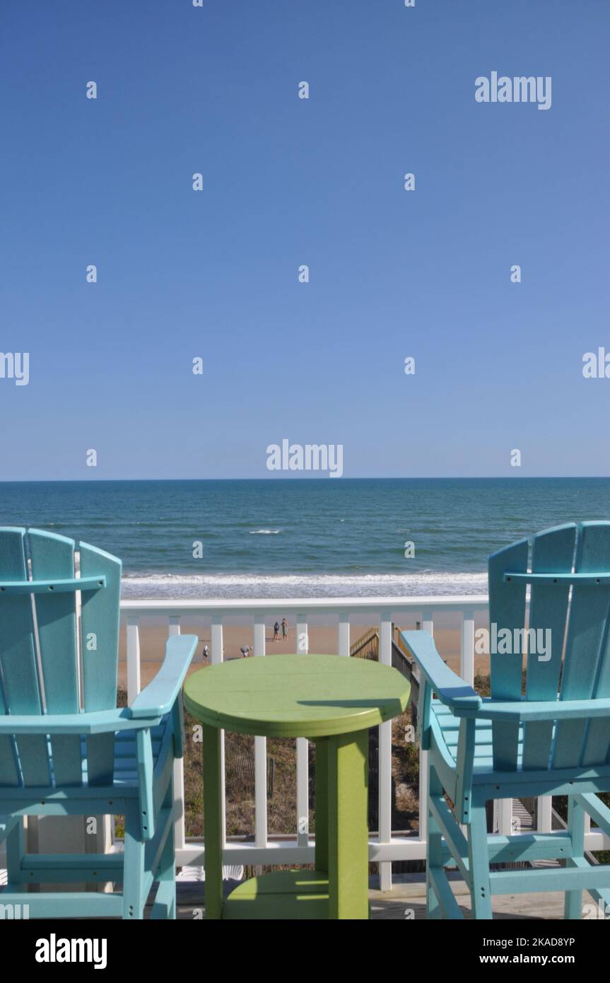 A vertical shot of two blue chairs and a green table overlooking the ...