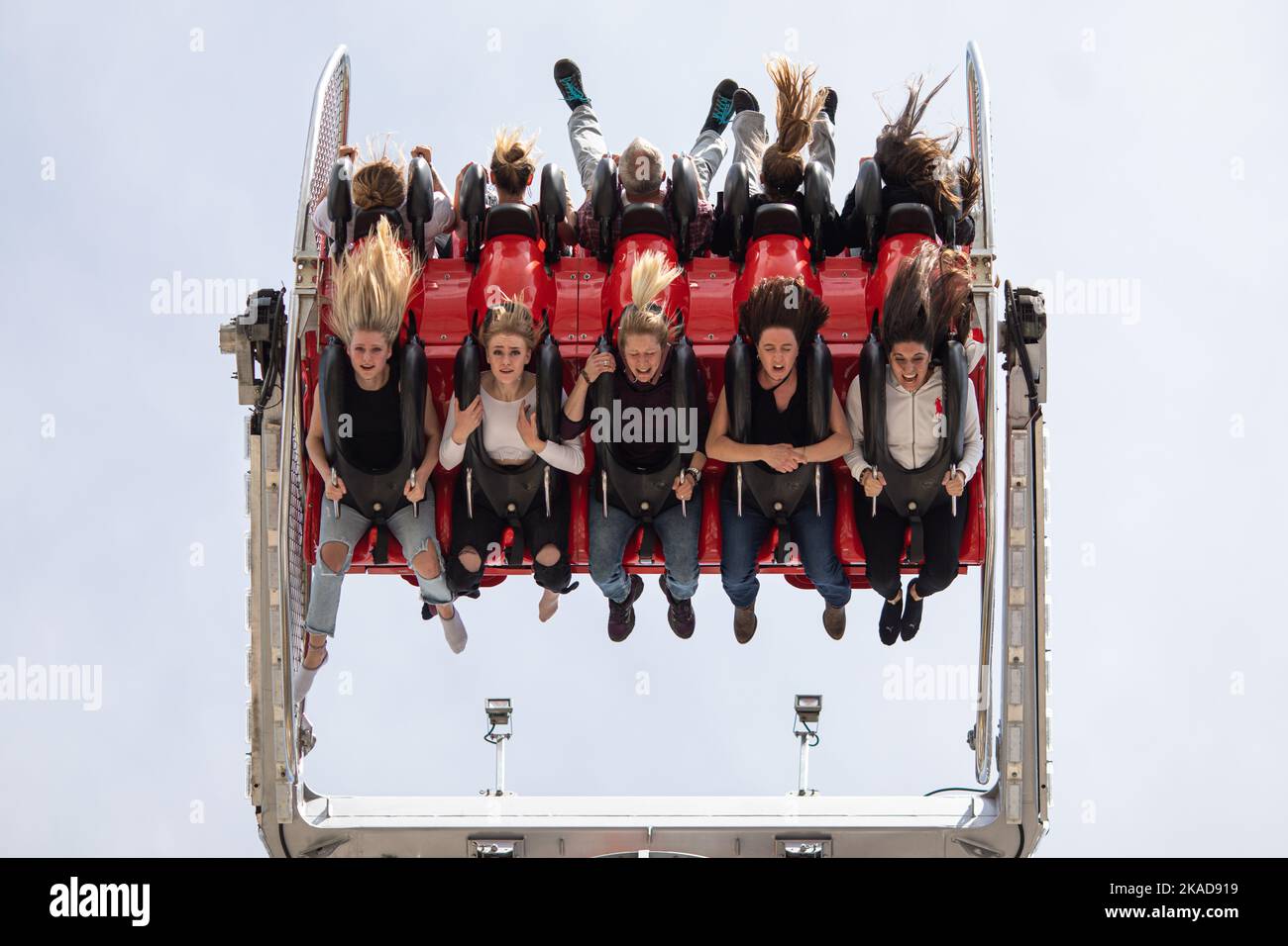 A low angle shot of people sitting on a carousel and shouting with ...