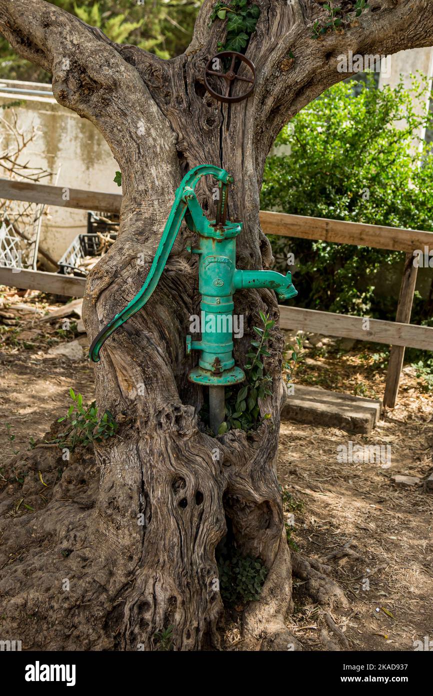 Old hand water pump on a well in the garden, watering and saving water ...