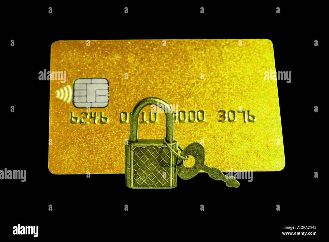Gold colored bank card, padlock and key isolated on black background ...