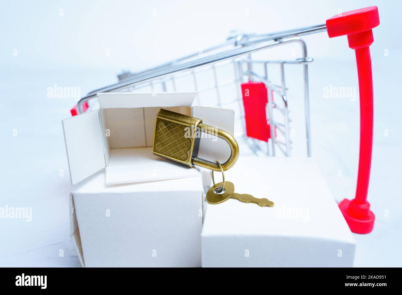 Small bronze toned padlock with key falling of a white delivery box ...