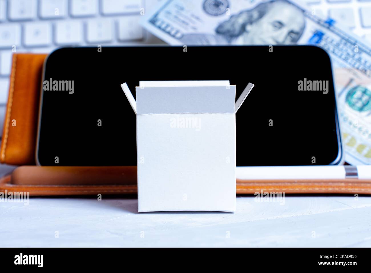 Mobile shopping concept: small delivery box placed in front of a black ...