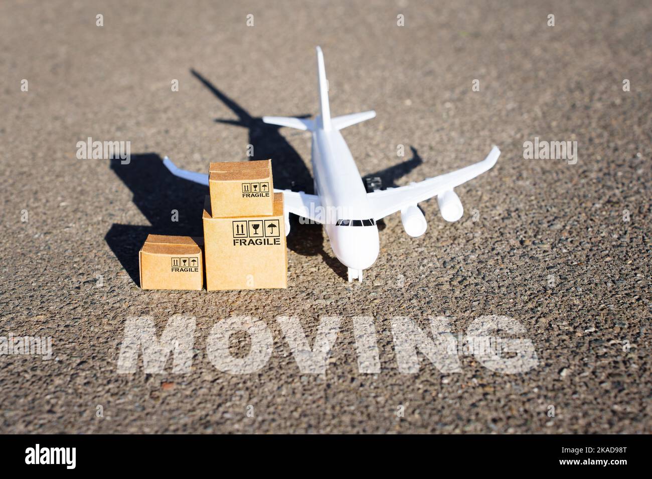 Toy aircraft and word MOVING written on the sidewalk. Creative ...
