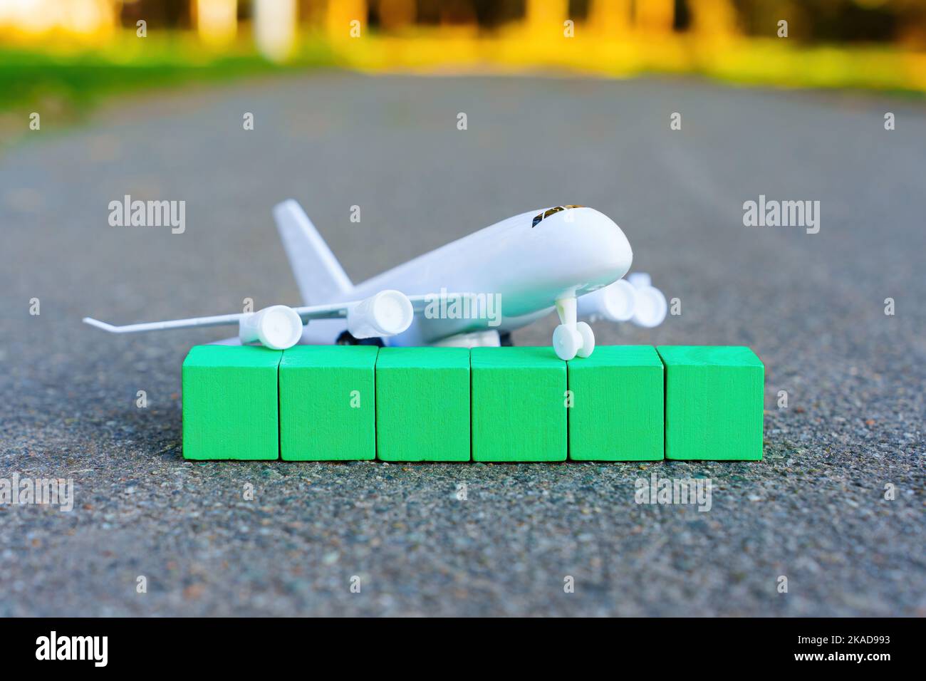 Aviation industry related mock-up: toy aircraft placed on green wooden ...