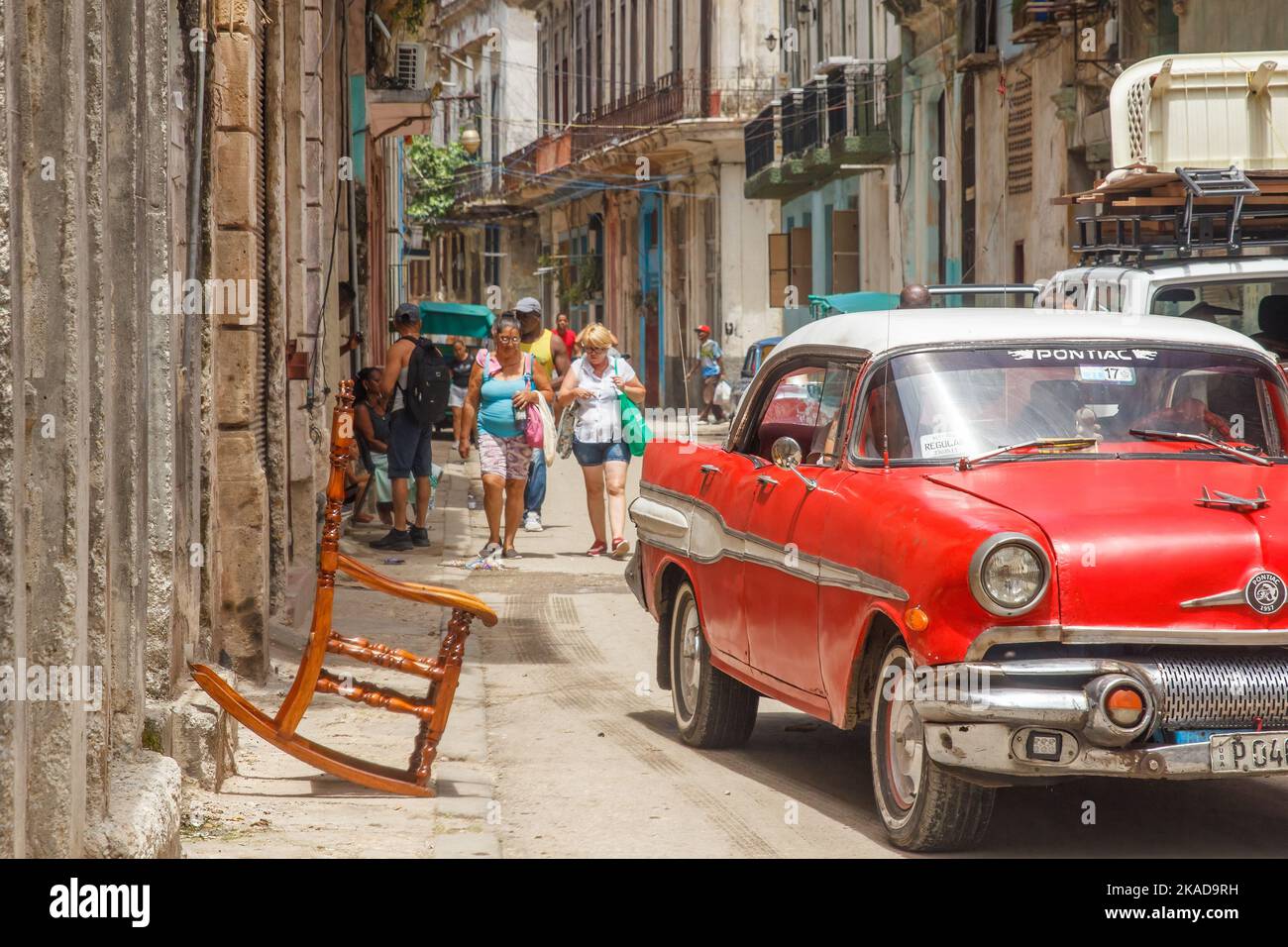 A rocking chair is on the sidewalk by run-down, old, weathered ...