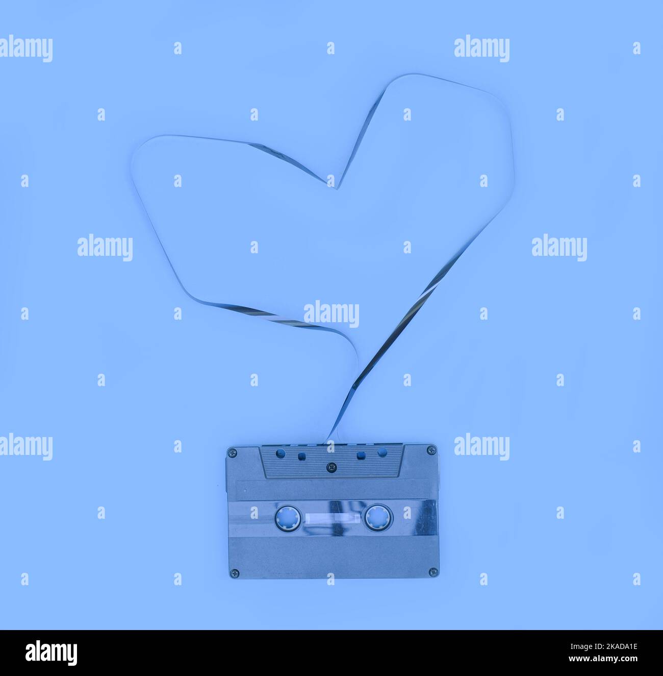 Audio cassette tape with tangled tape ribbon heart shape at blue ...