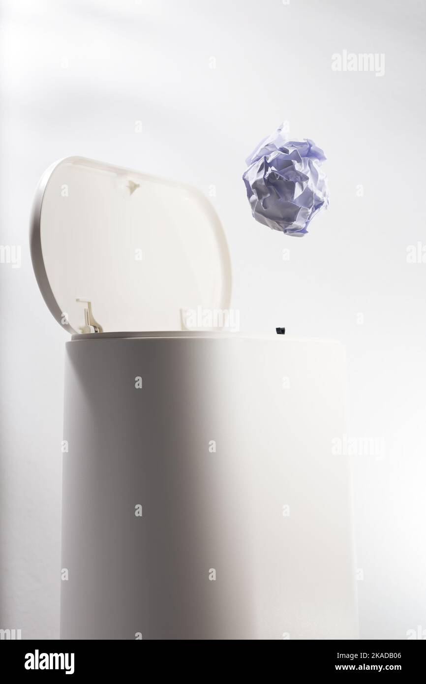 Throwing a paper ball into a white plastic garbage bin Stock Photo - Alamy