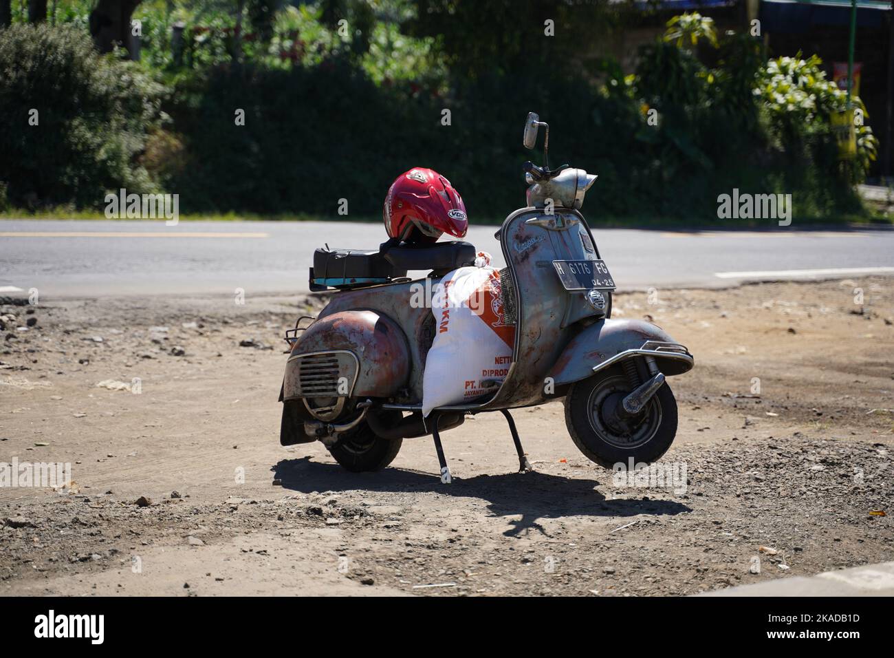A vintage Vespa motorbike on the side of the highway in Jawa Tengah ...