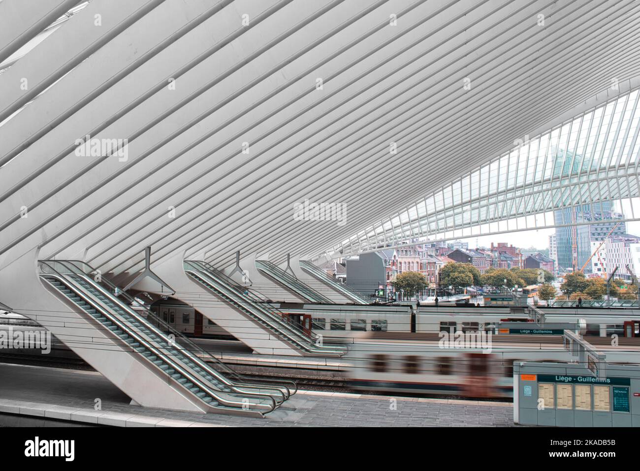 The architecture of a modern train station with trains in motion in ...