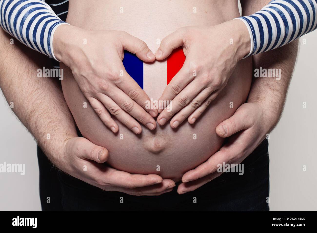 French family concept. Man embracing pregnant woman belly and heart ...