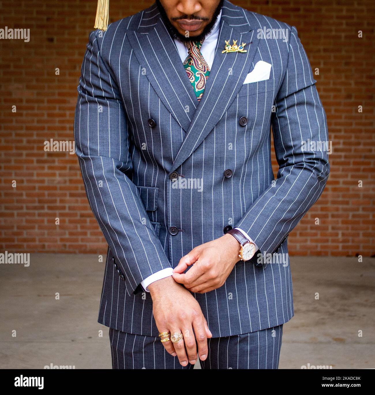 A man in a beautiful blue suit wearing a watch standing in front of a ...