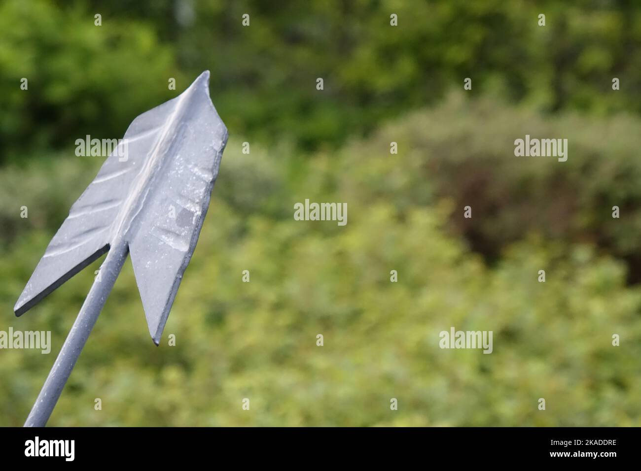 Metal arrow tip pointing right in spring, concept: target, focus, task ...