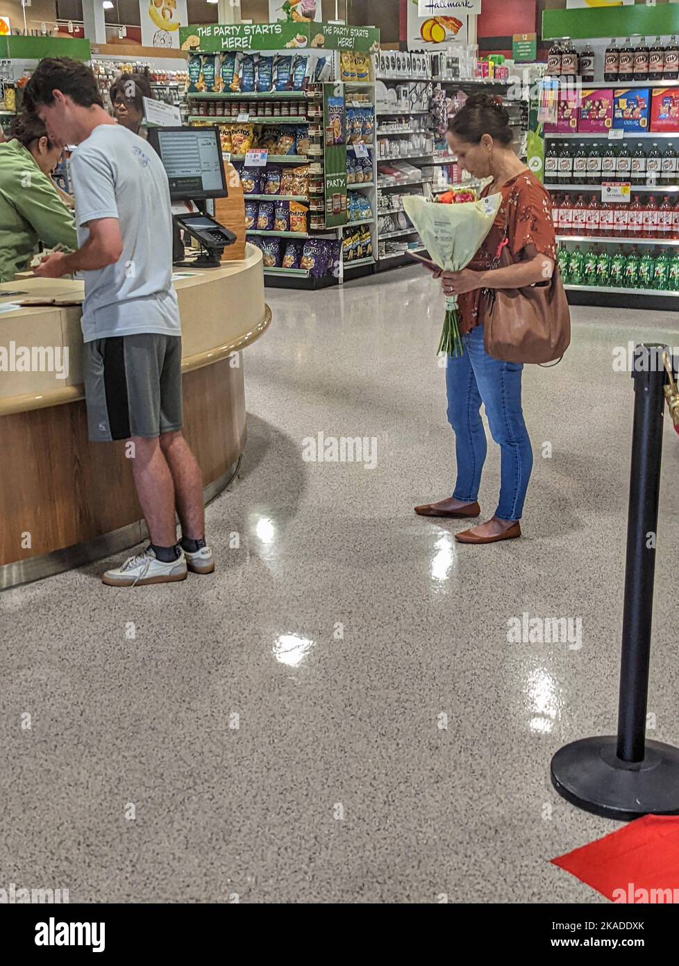 A vertical of people waiting in line at the customer service counter at ...