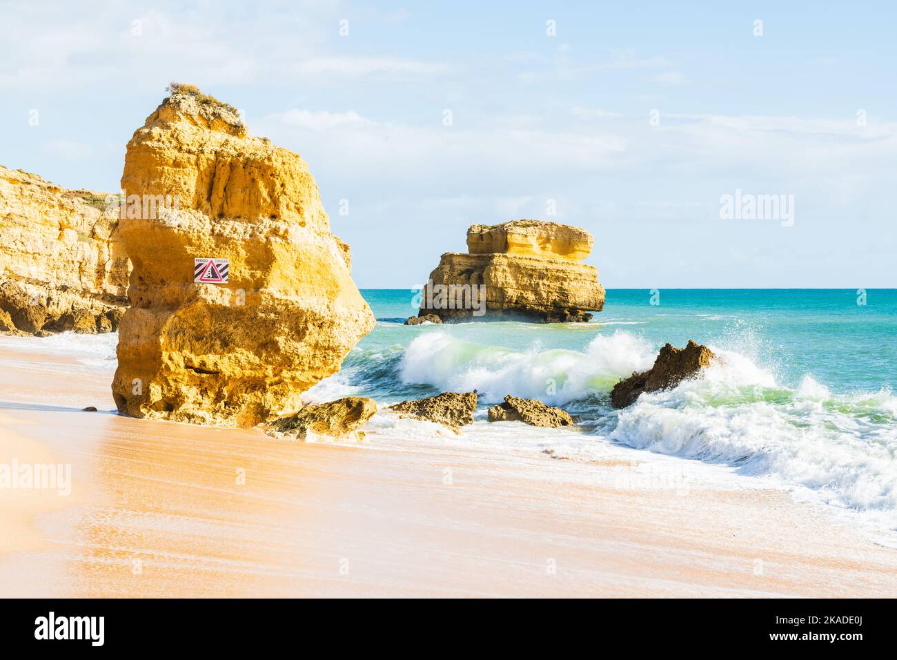 Rock formation on sandy beach with waves Stock Photo - Alamy