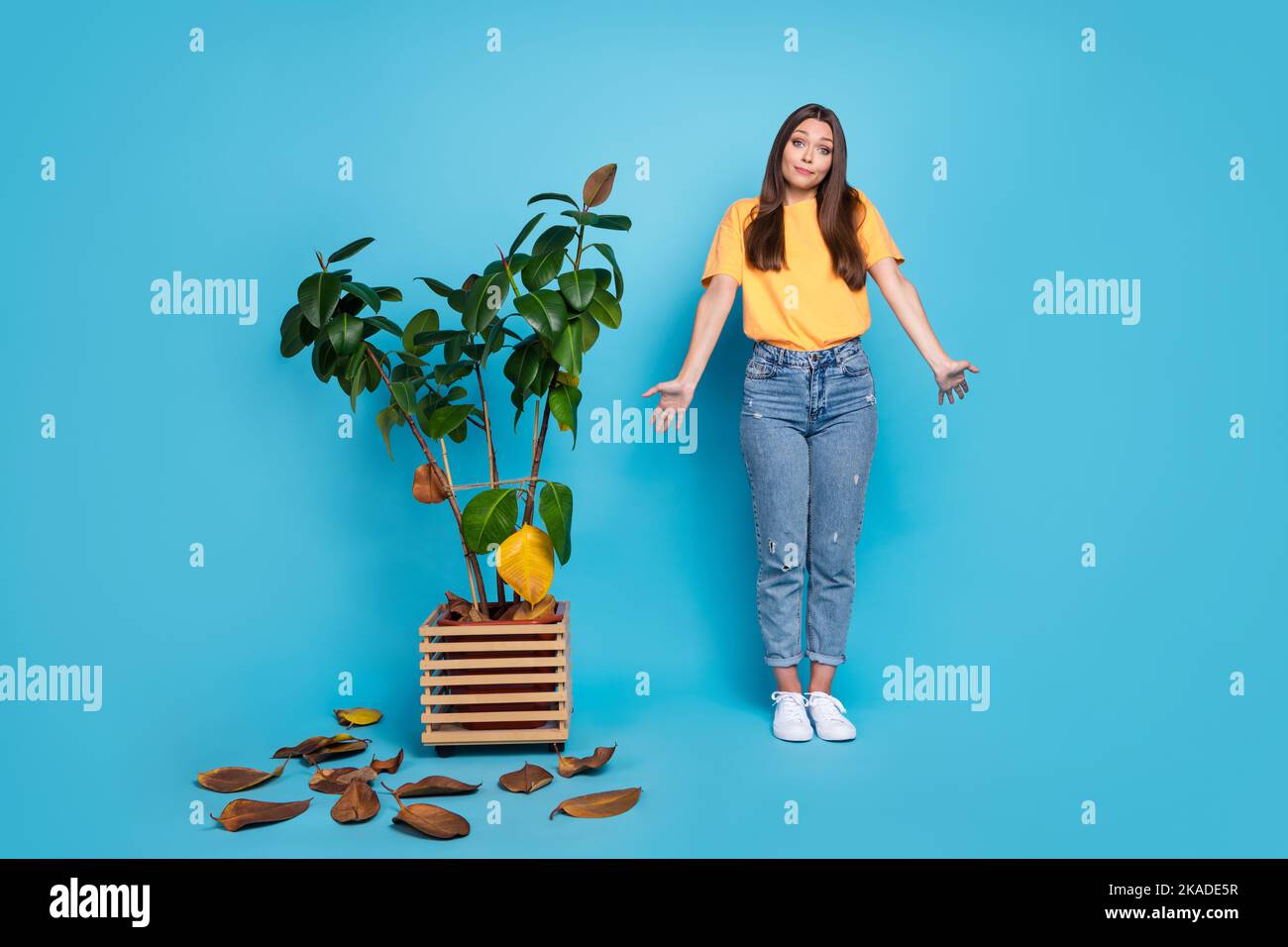 Photo of funny funky young lady wear yellow t-shirt shrugging shoulder ...