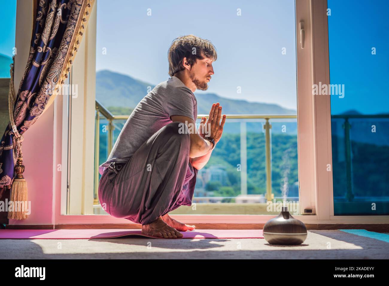 Mindful healthy man practicing yoga at home. Sitting on the floor doing ...