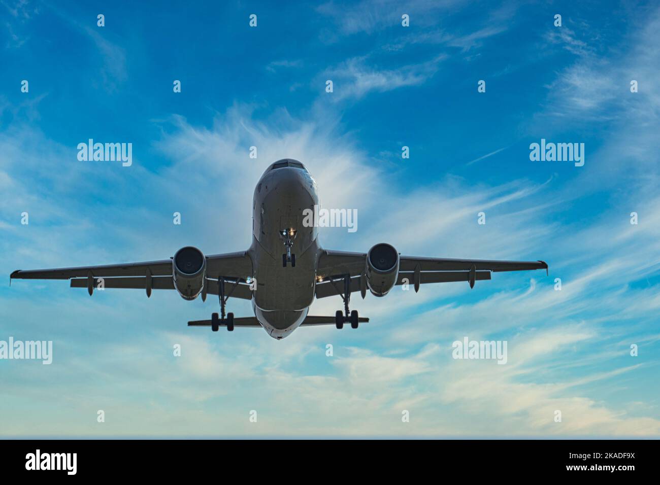 large passenger plane on approach for landing, front view, from below ...