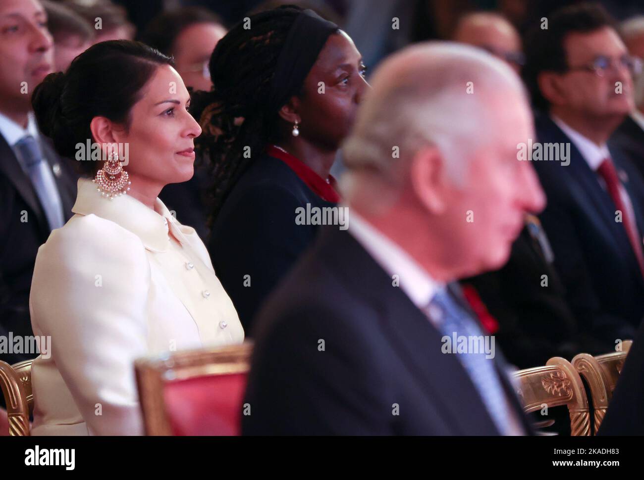 Former home secretary Priti Patel sits behind King Charles III during a ...