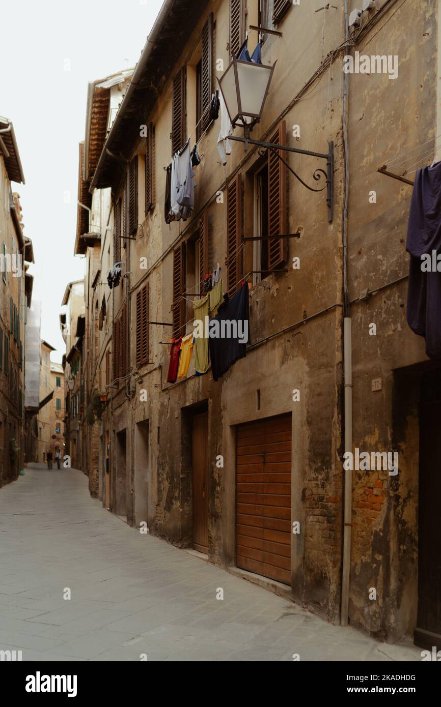 A vertical closeup of a narrow alleyway between old stone buildings in ...