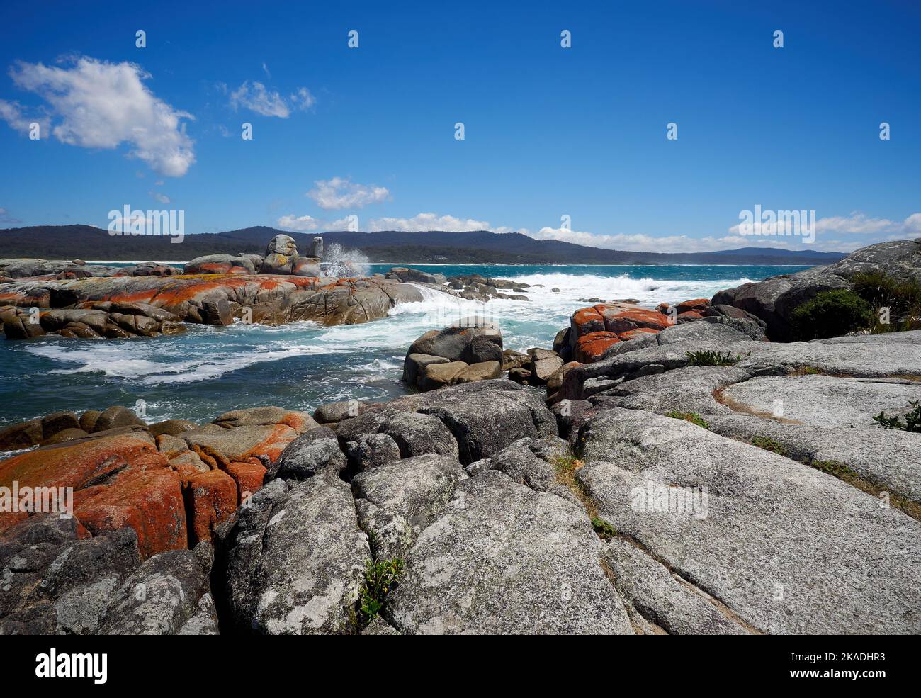 An aerial view of the rocky Binalong Bay under a blue sky in Australia ...