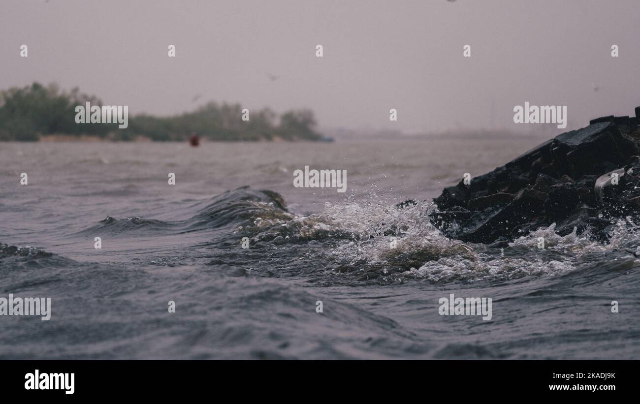 The waves crashing into the rocks making foam on a windy day Stock ...