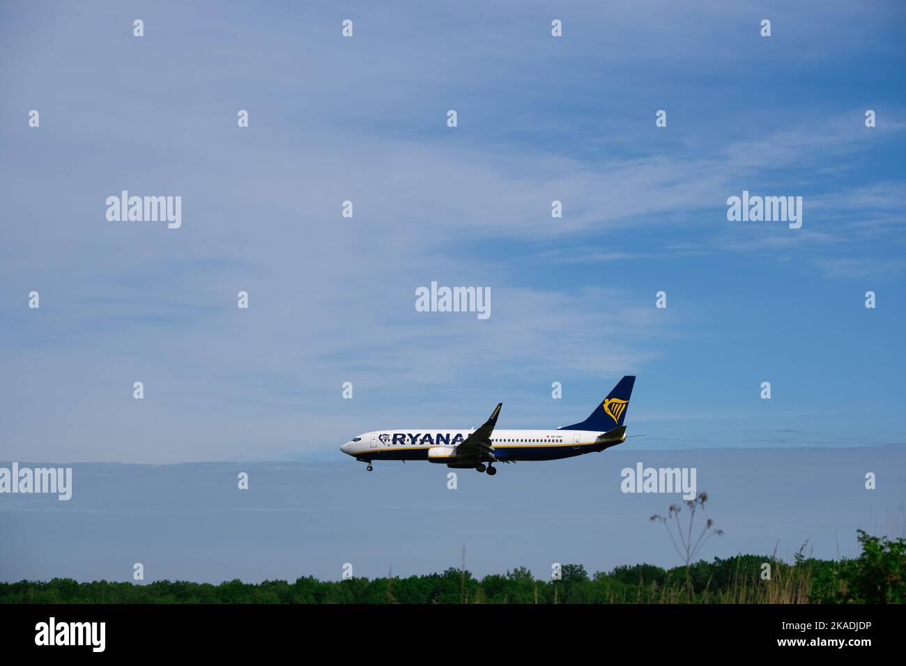 airplane on approach for landing, rear view just before landing, blue ...