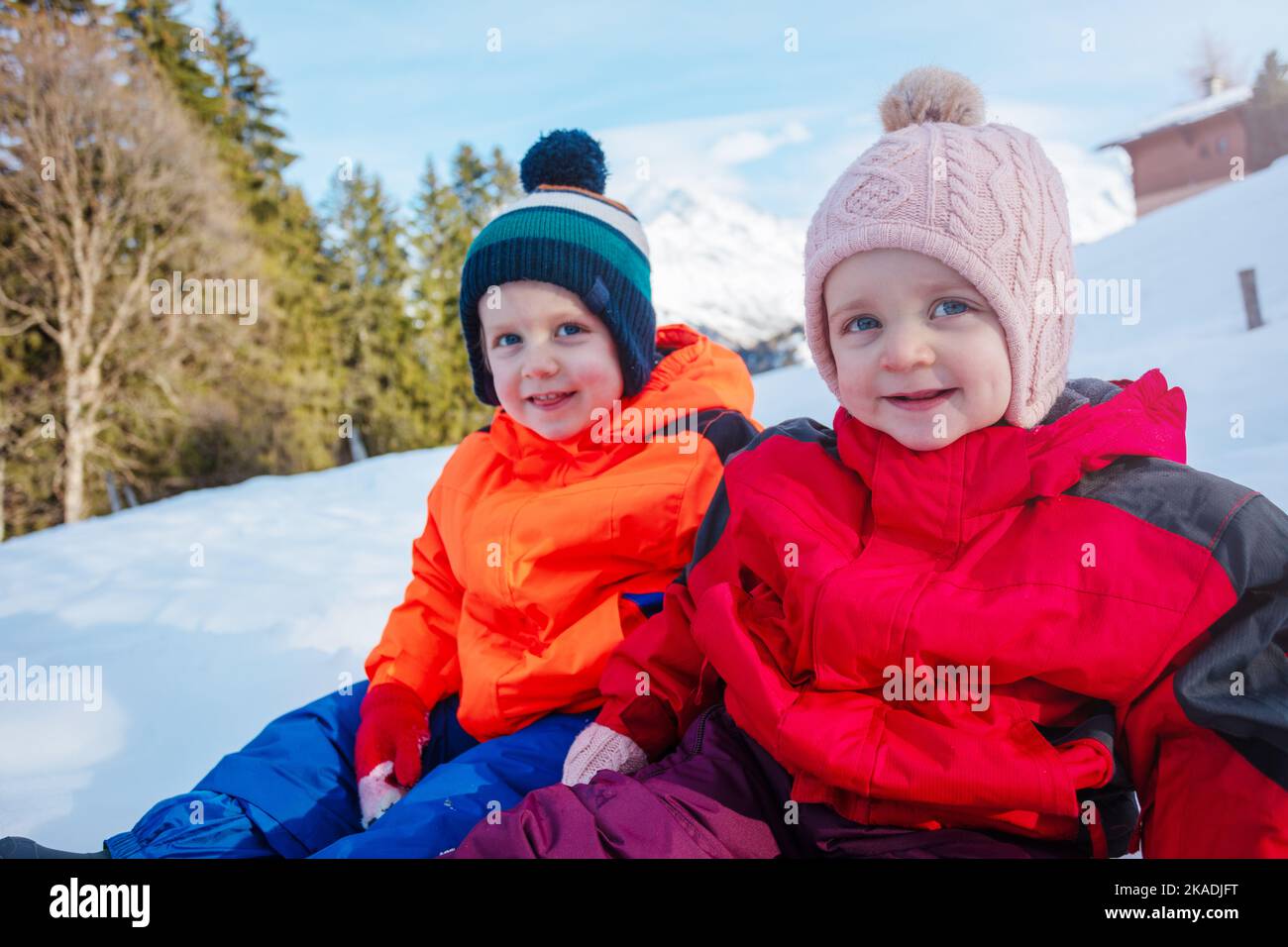 Close portrait of two happy kids boy, girl sit in snow smiling Stock ...