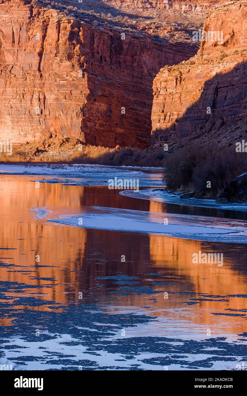 Orange sandstone cliffs reflected on the surface of the partially ...